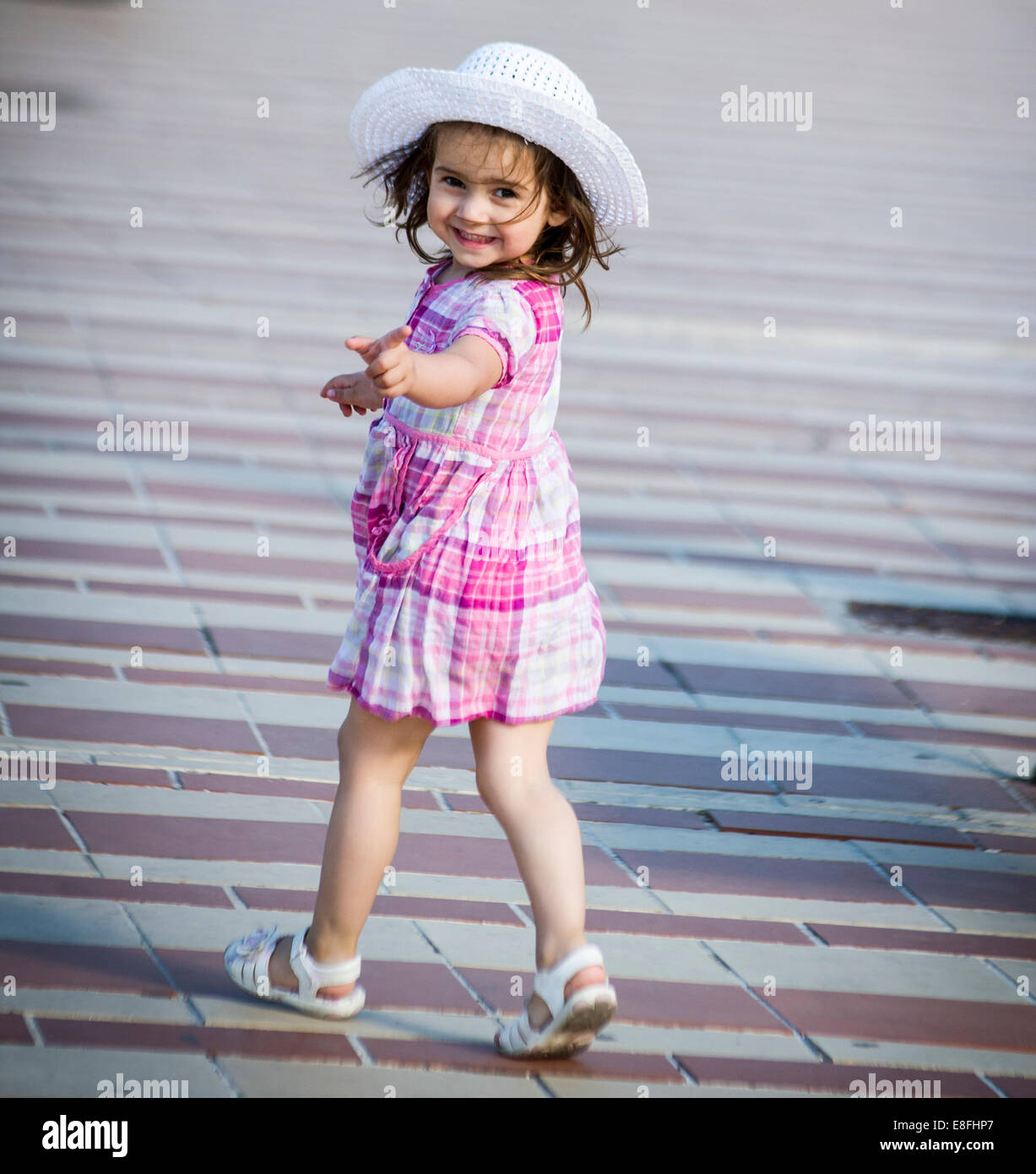 Smiling girl walking and looking over her shoulder Stock Photo - Alamy