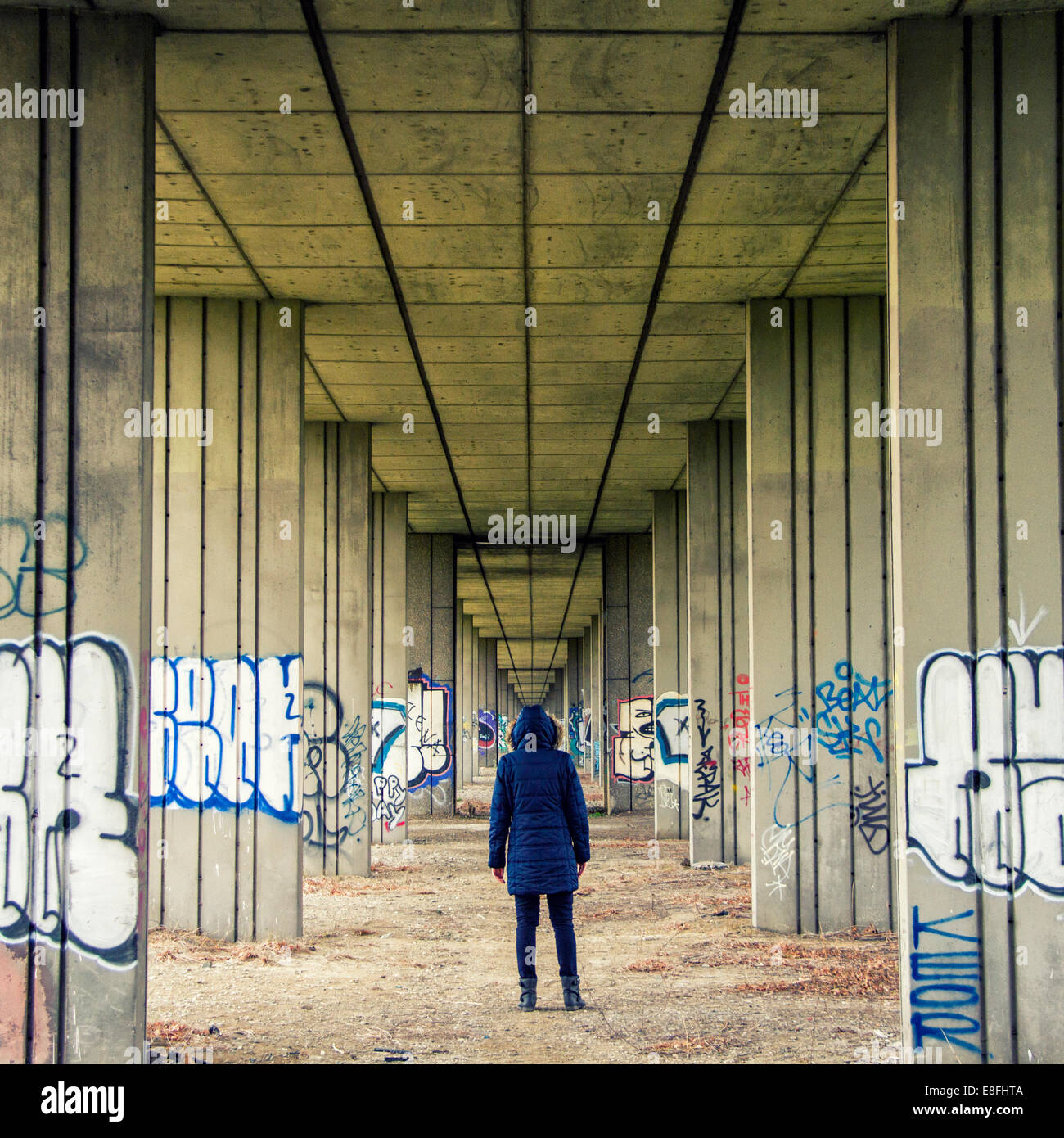 Rear view of woman under bridge Stock Photo - Alamy