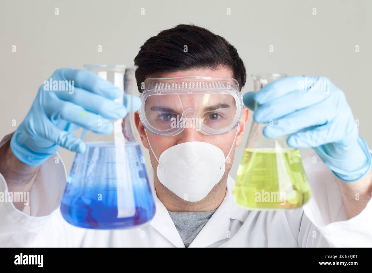 Scientist holding two conical flasks Stock Photo - Alamy
