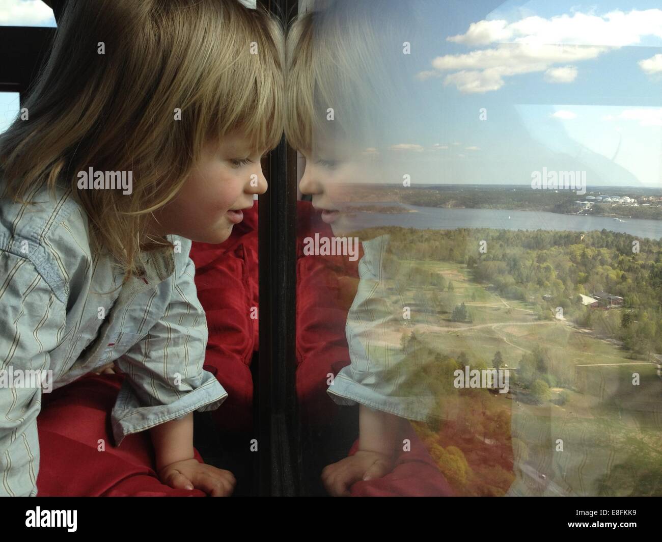 Boy looking at his reflection in a window Stock Photo - Alamy