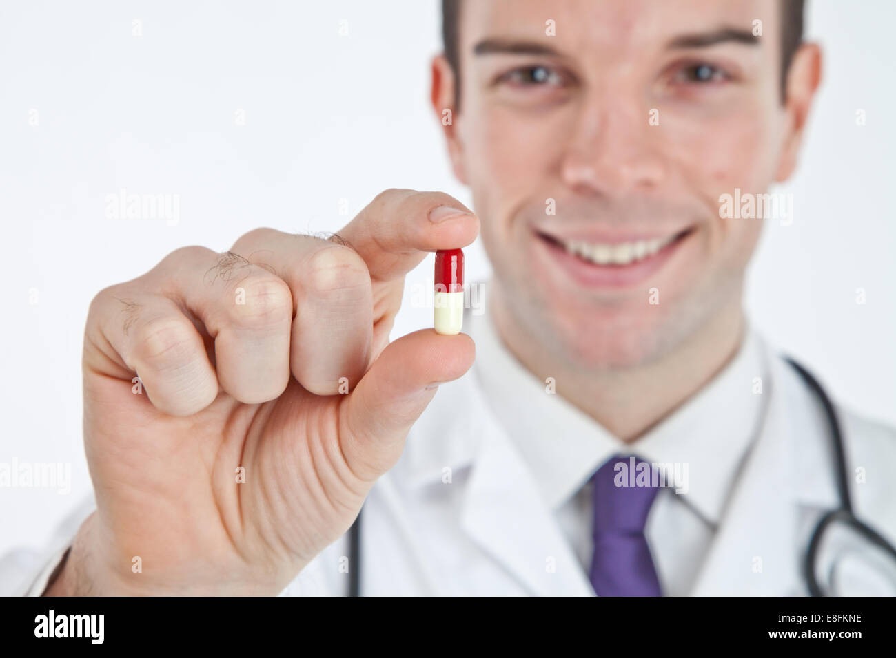 Close-up of a smiling male doctor holding a capsule Stock Photo - Alamy