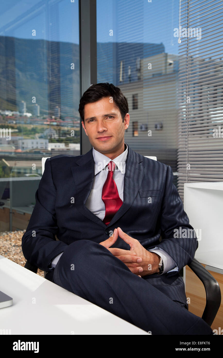 Portrait of a Businessman sitting at his desk in office Stock Photo - Alamy