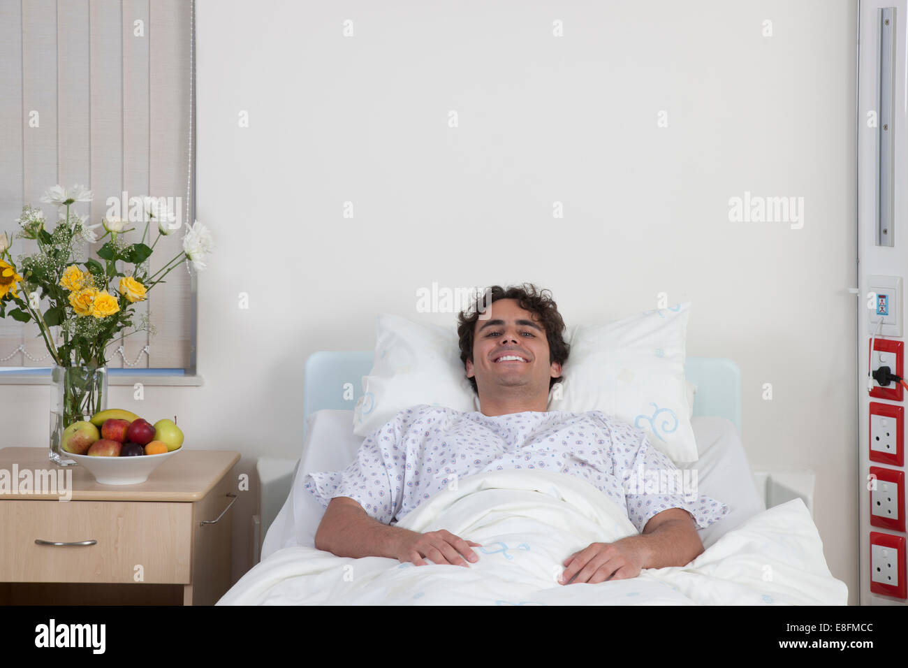 Smiling man in recovery lying in hospital bed on hospital ward Stock ...