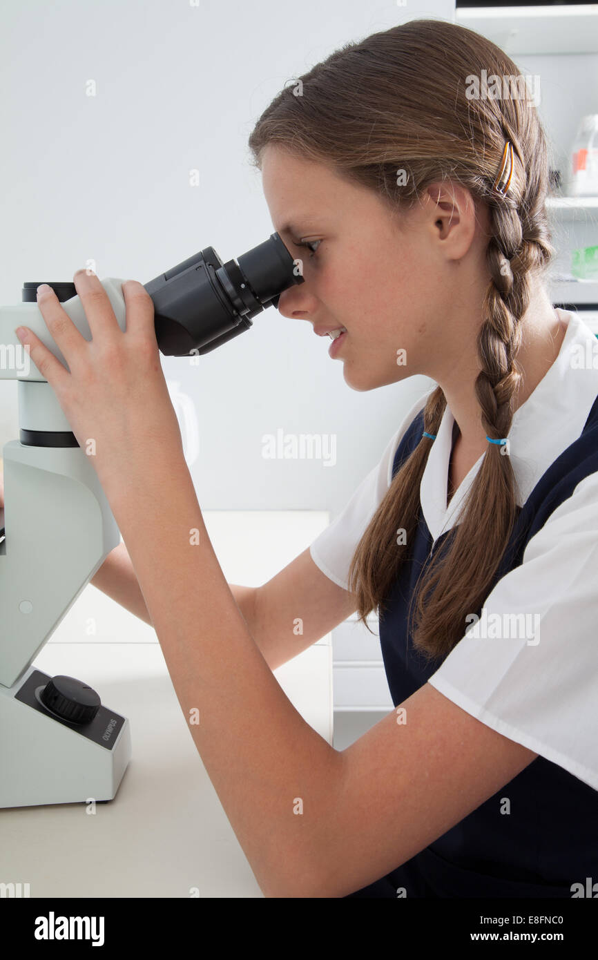 Teenage Girl Using Microscope in school laboratory Stock Photo - Alamy