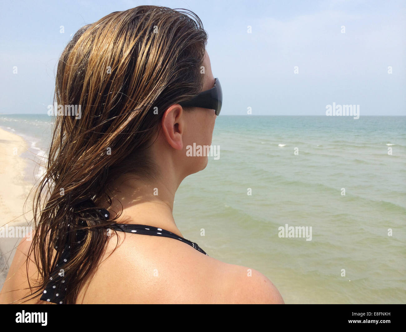 Woman looking out to sea, on beach Stock Photo - Alamy