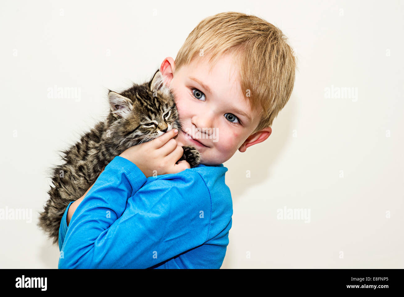 Portrait of a boy holding a kitten Stock Photo - Alamy