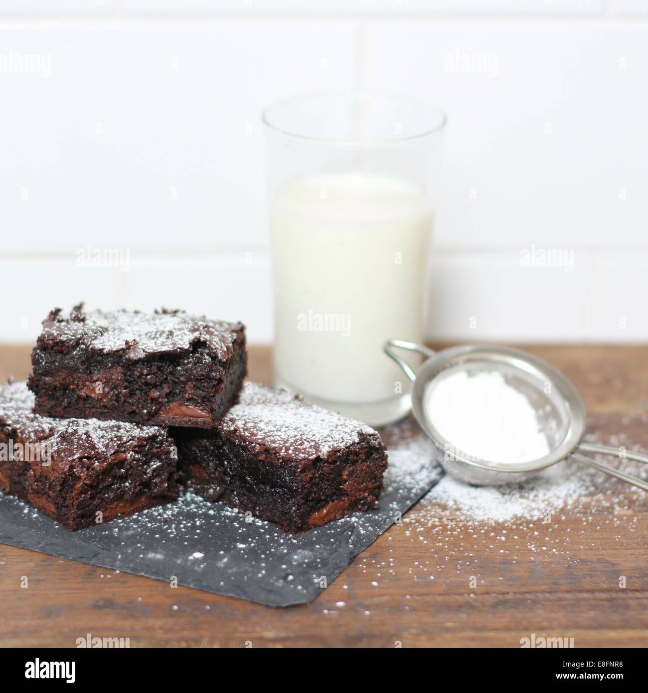 Chocolate brownies dusted with icing sugar and glass of milk Stock ...