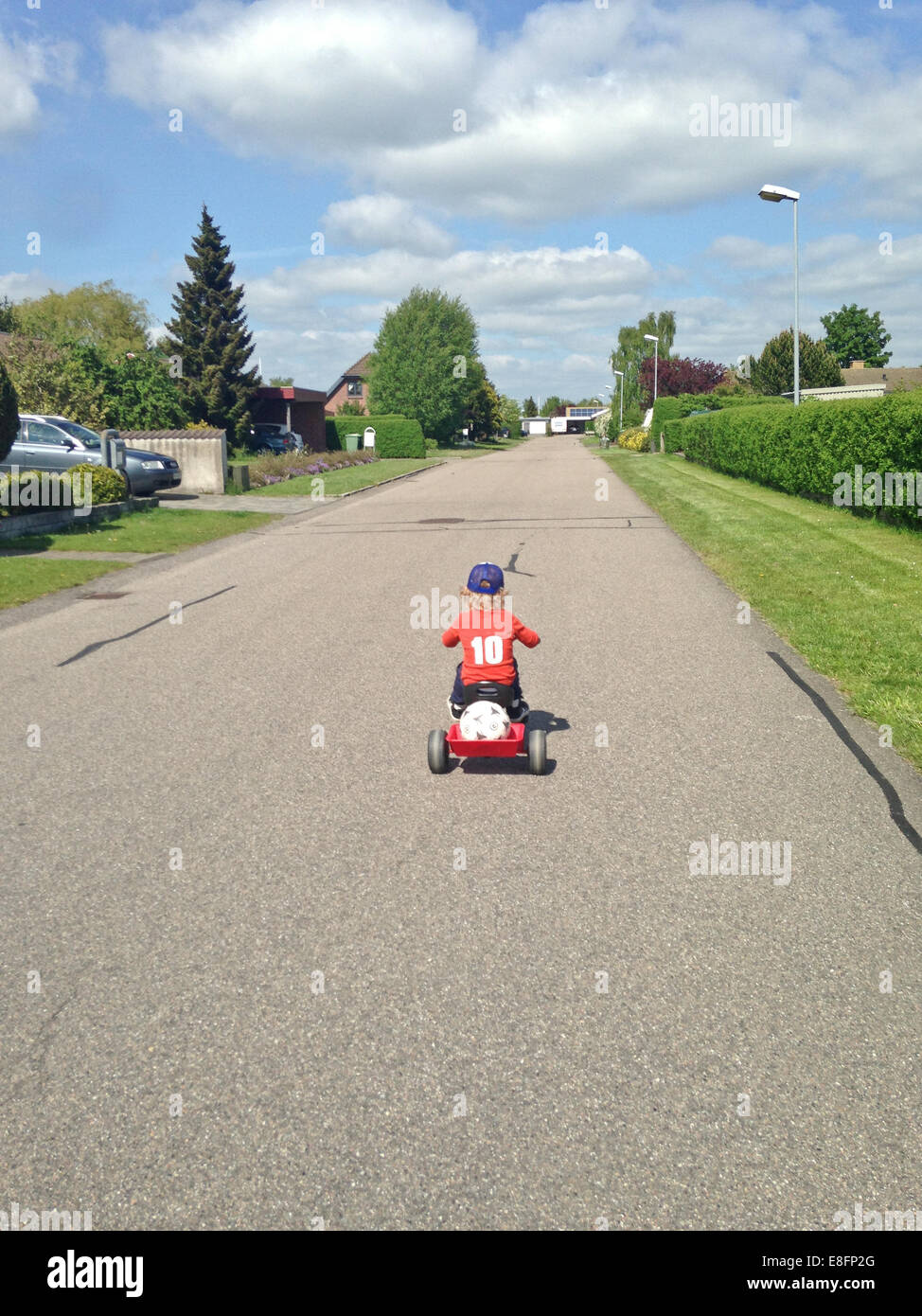 Rear view of a boy cycling along road on his tricycle, Denmark Stock ...