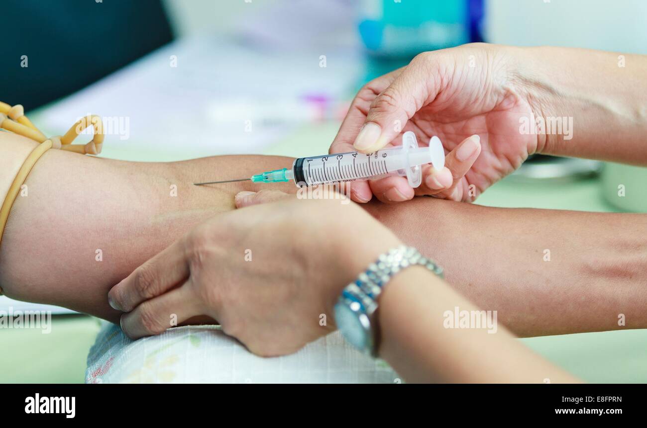 Doctor drawing blood sample from arm for blood test Stock Photo - Alamy