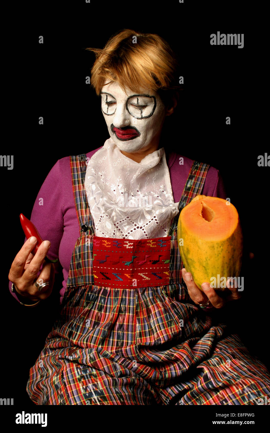 Female Clown holding a chili pepper and marrow Stock Photo - Alamy