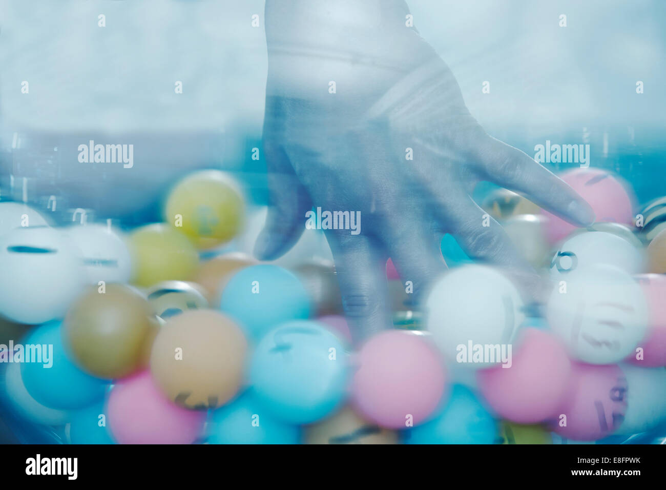Close-up of hand picking lottery ball from glass bowl Stock Photo - Alamy