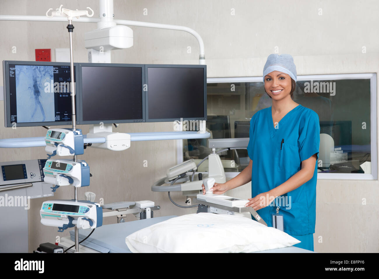 Confident nurse standing by CT scanner Stock Photo - Alamy