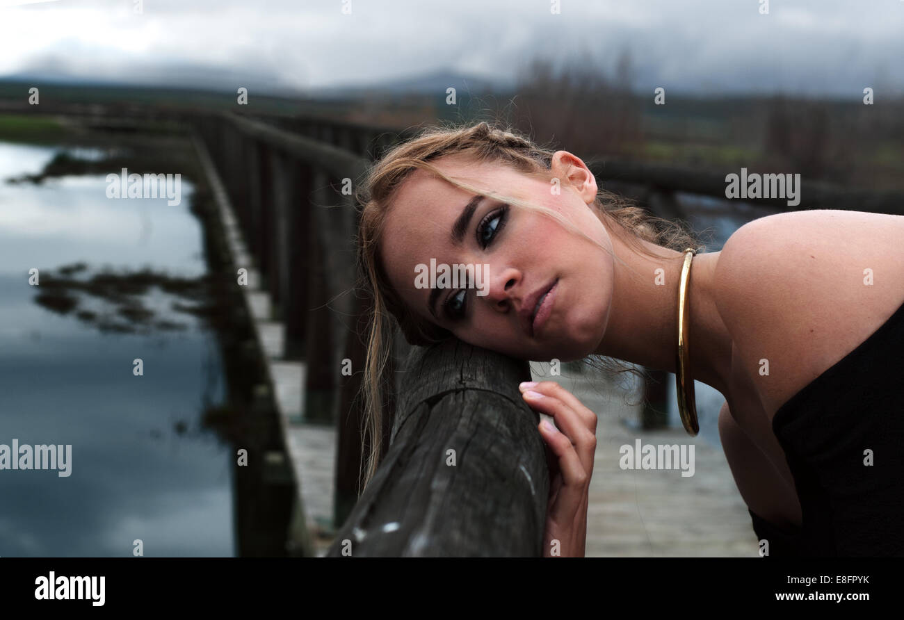 Fashion model leaning on railing of bridge Stock Photo - Alamy
