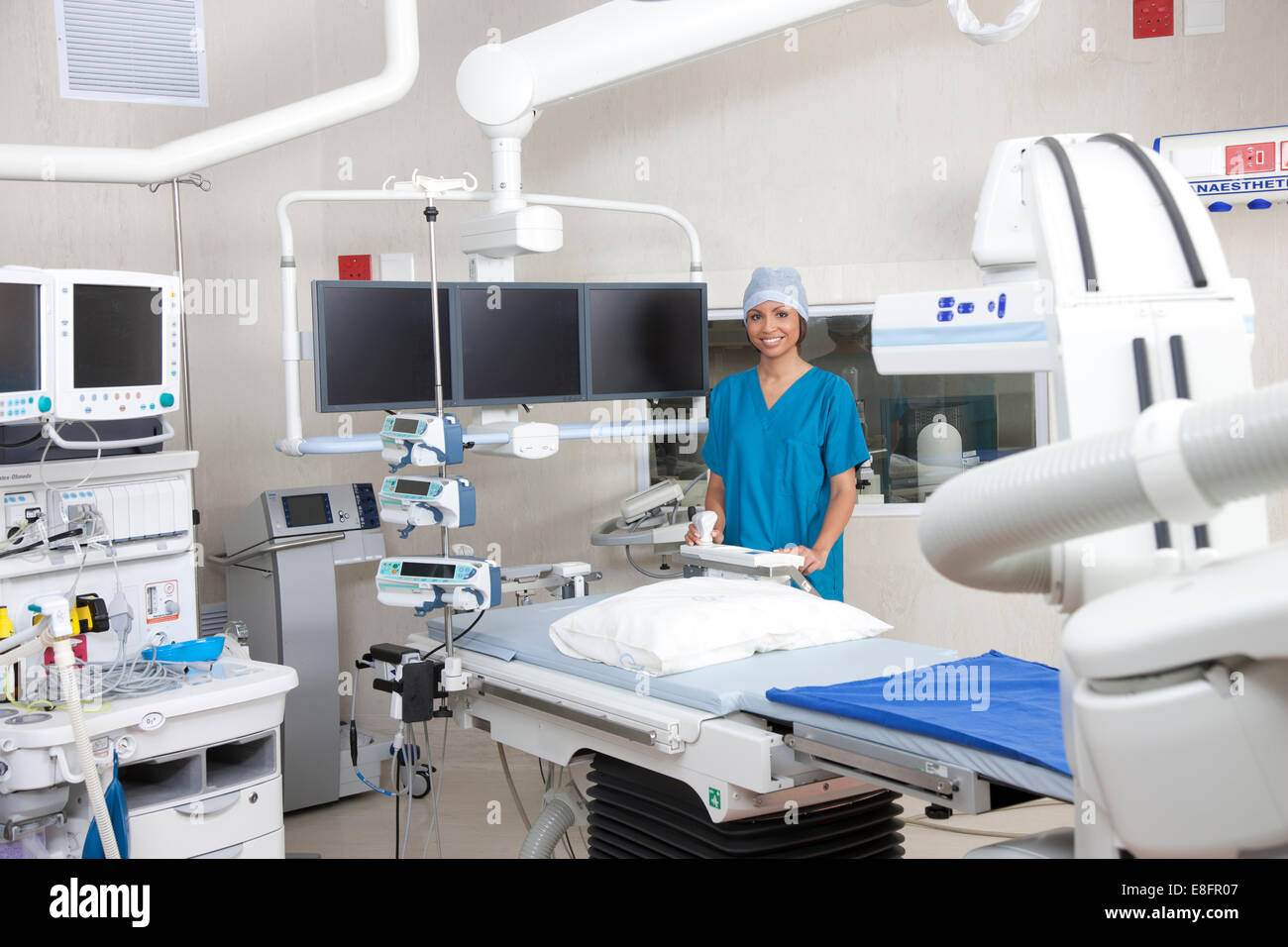 Doctor standing in operating theatre with robotic imaging system Stock ...