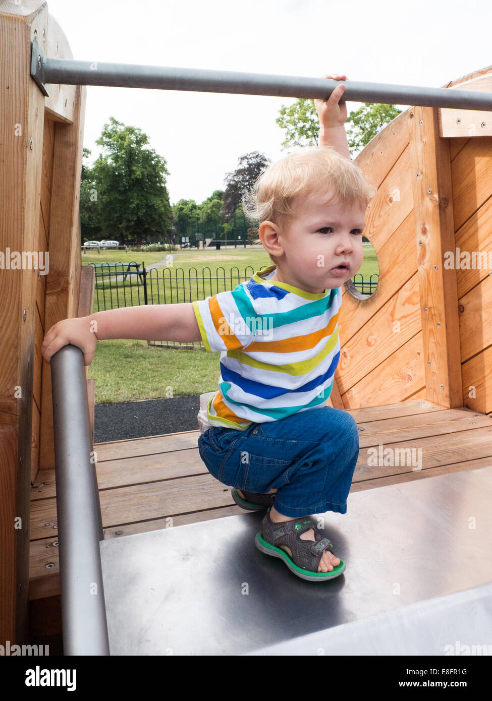 Boy on playground slide Stock Photo - Alamy