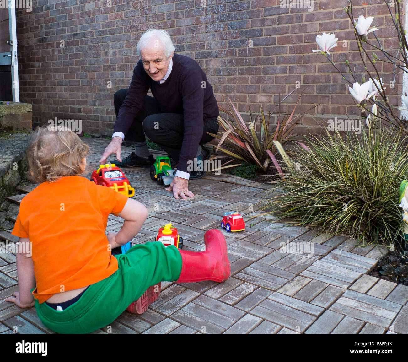 Grandfather and grandson playing with toys in garden Stock Photo - Alamy