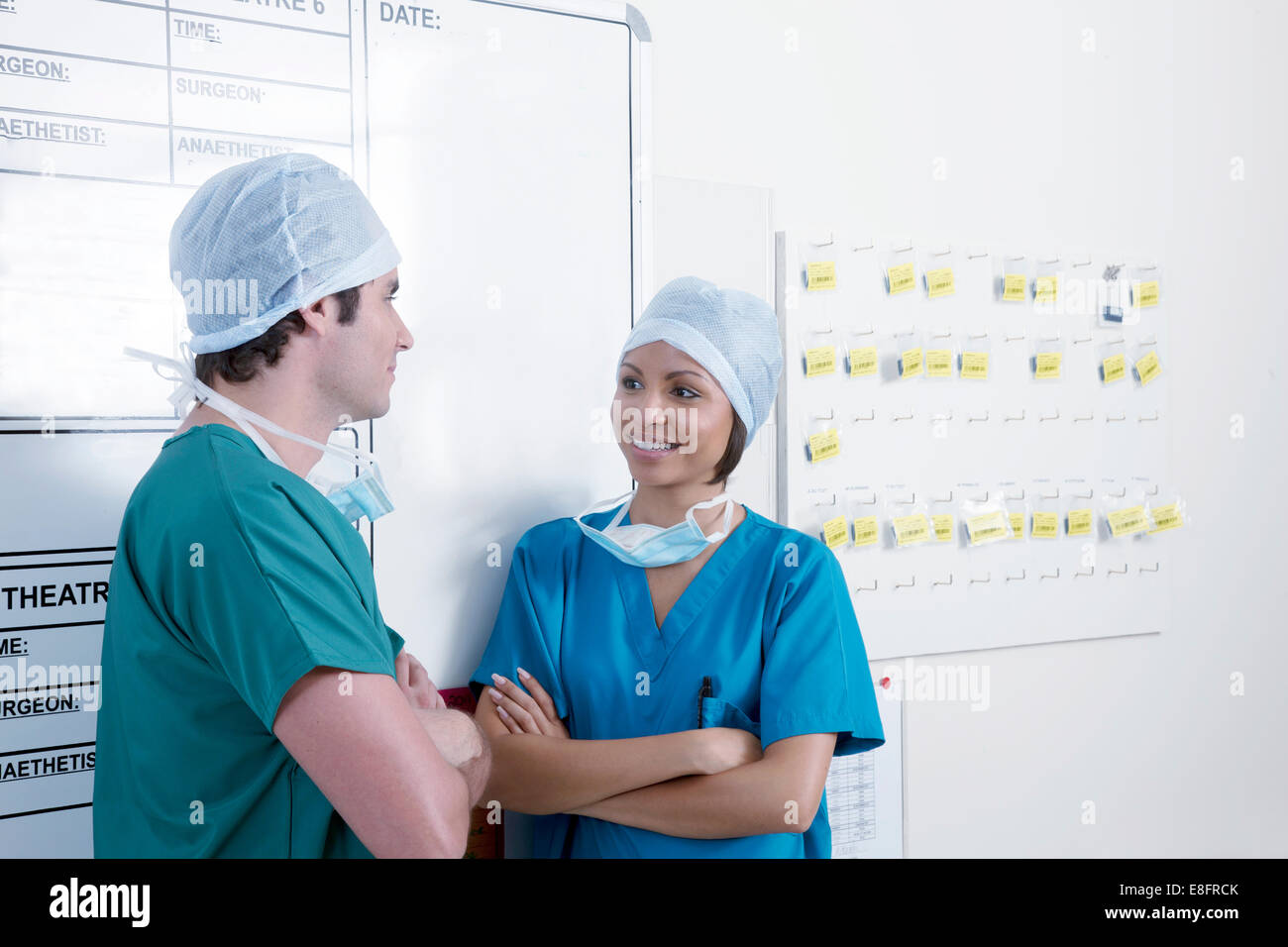 Two doctors standing by a whiteboard talking Stock Photo - Alamy