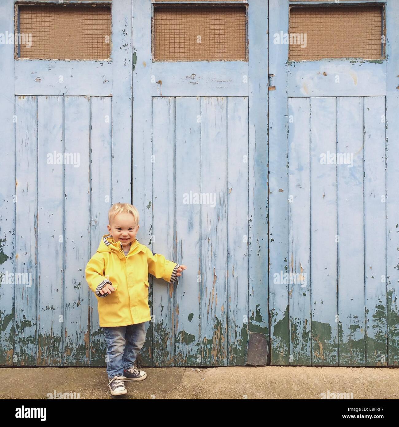 Smiling boy standing outside a garage Stock Photo - Alamy