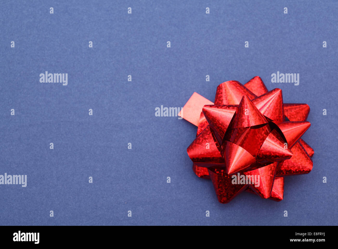 Red bow on blue paper background. Closeup Stock Photo - Alamy