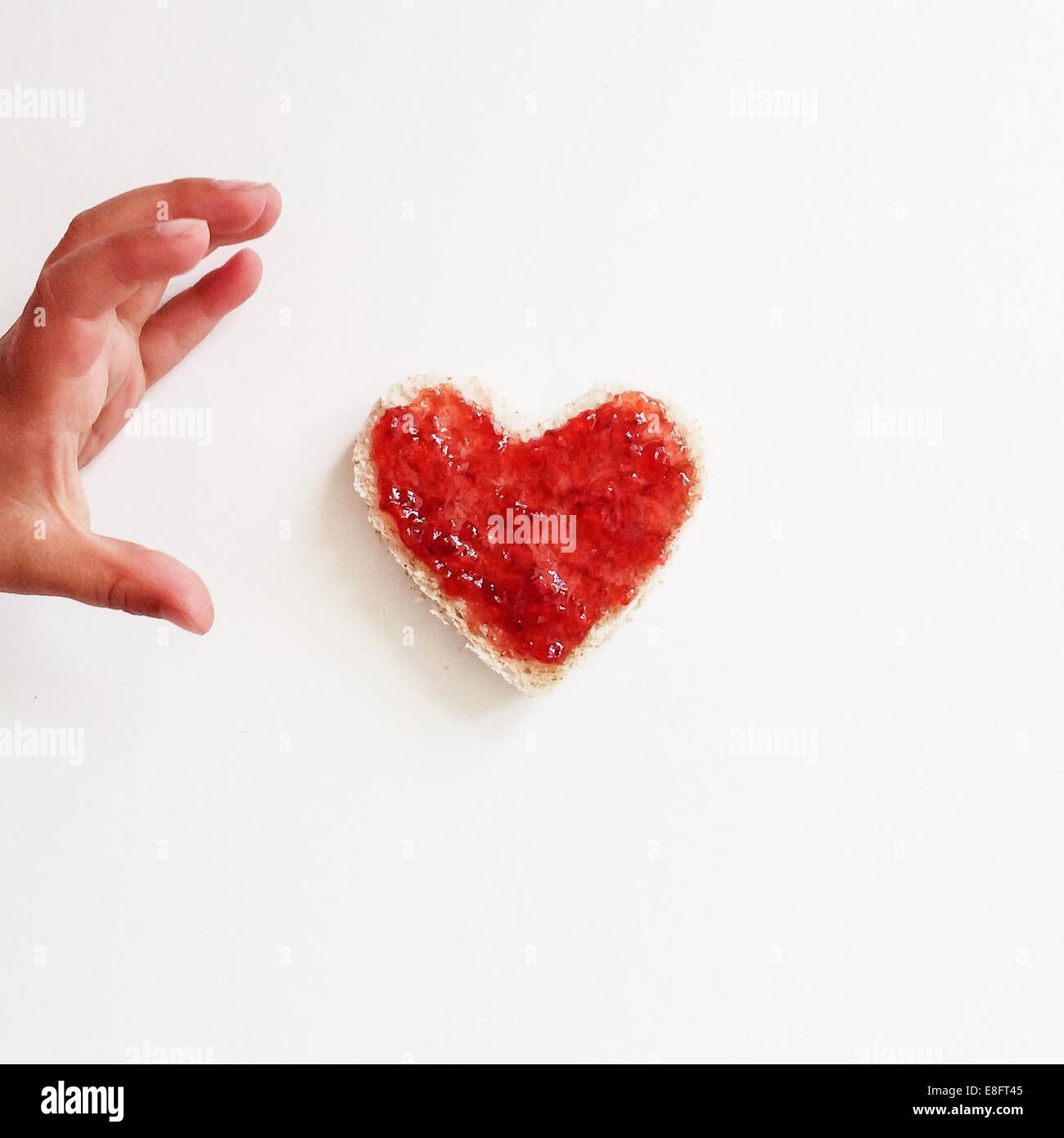 Boy reaching for heart shaped slice of bread and jam Stock Photo - Alamy