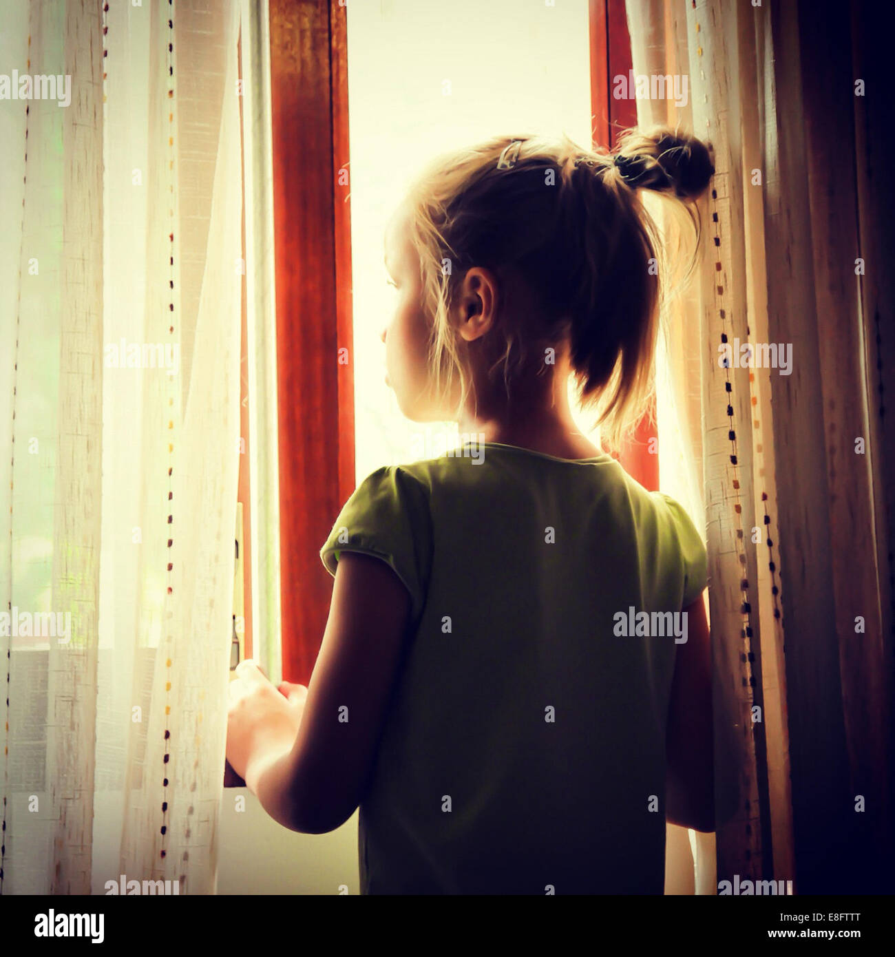 Rear view of girl looking out of window Stock Photo - Alamy
