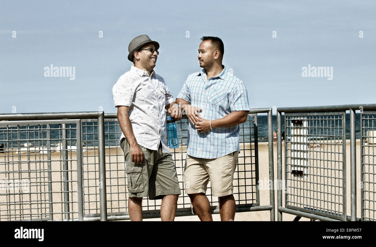 Two men standing on beach talking, Chicago, Illinois, United States ...