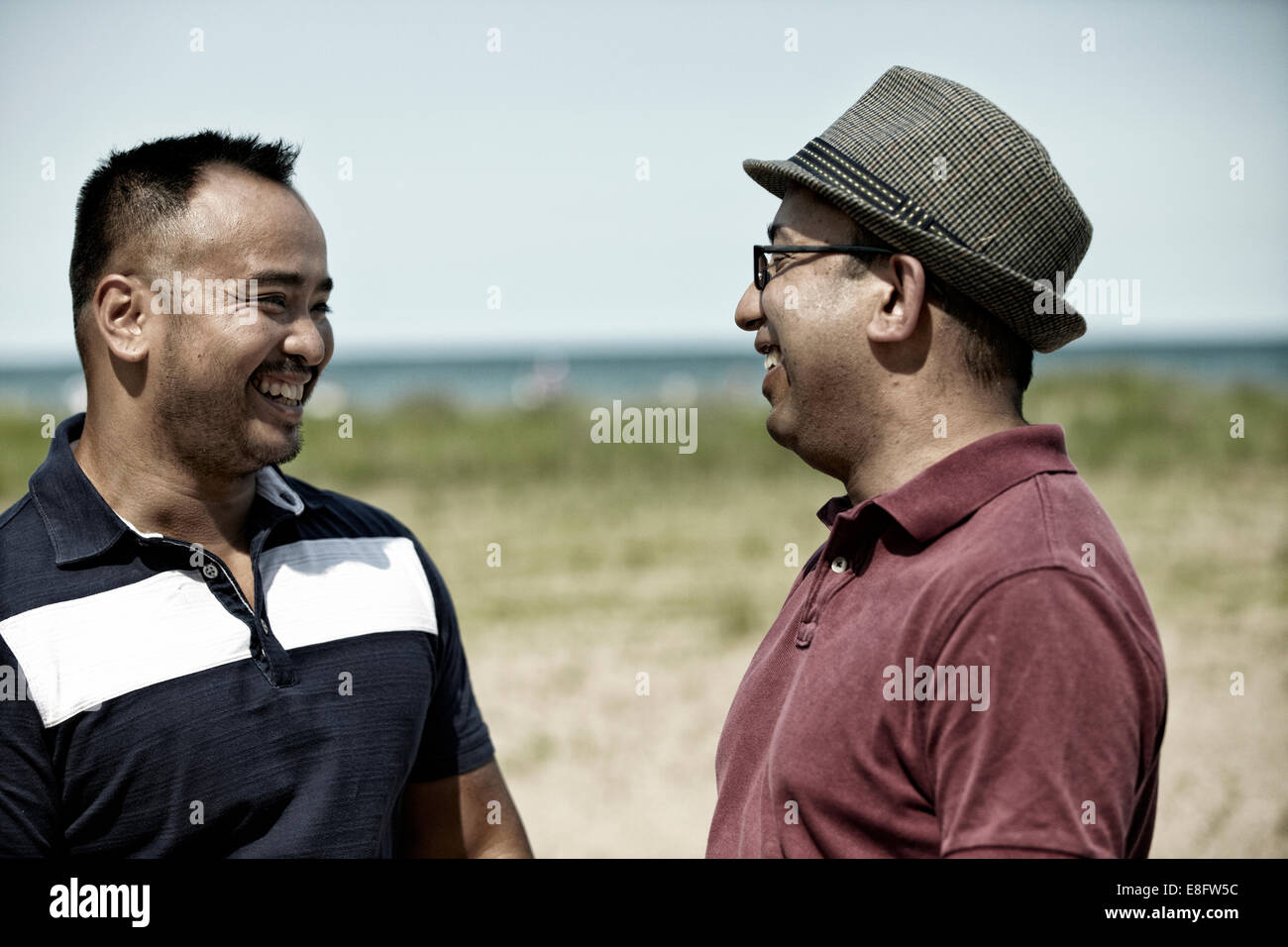 Portrait of two men talking on beach, Chicago, Illinois, United States ...