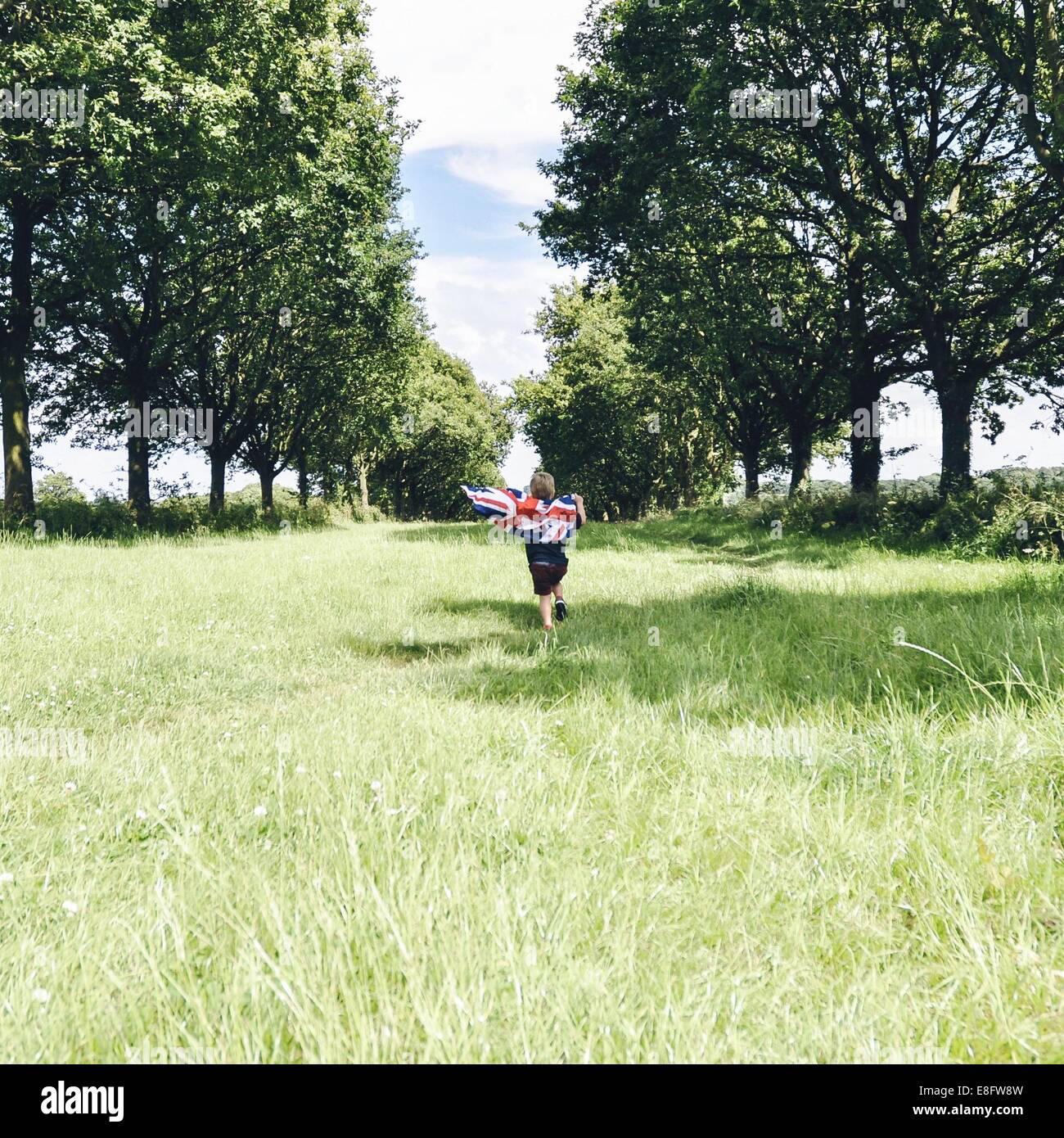 Boy running through field holding Union Jack flag Stock Photo - Alamy