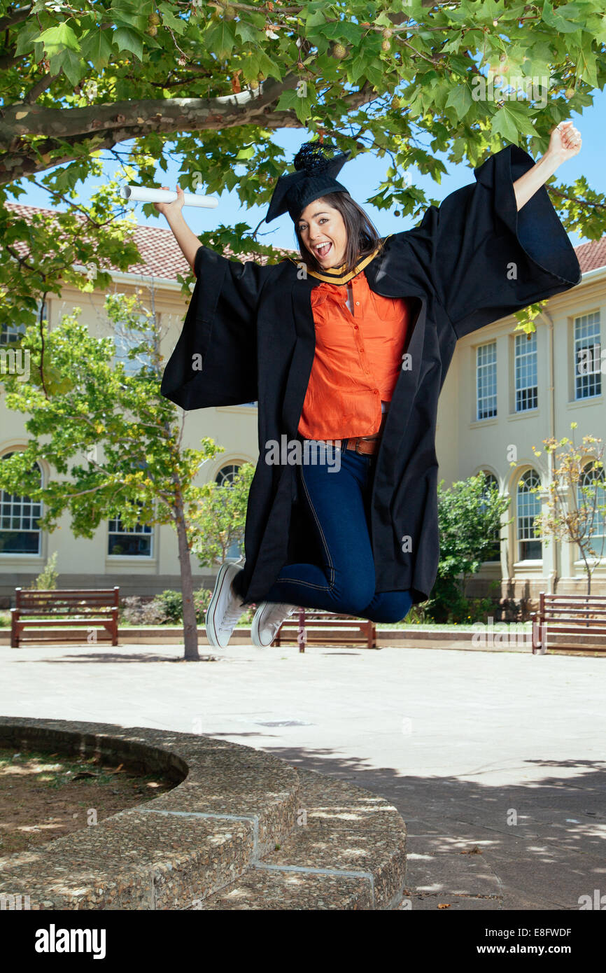 Young female graduate jumping in the air Stock Photo - Alamy