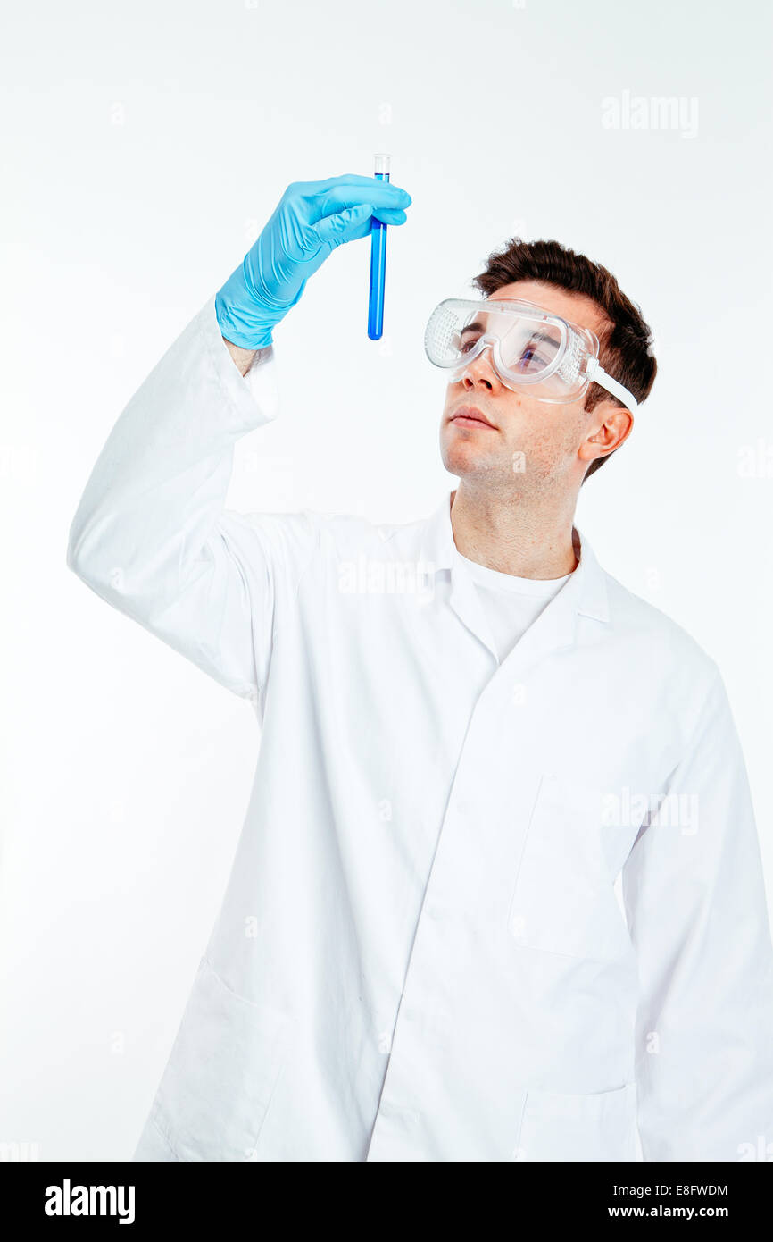 Scientist looking at test tube Stock Photo - Alamy