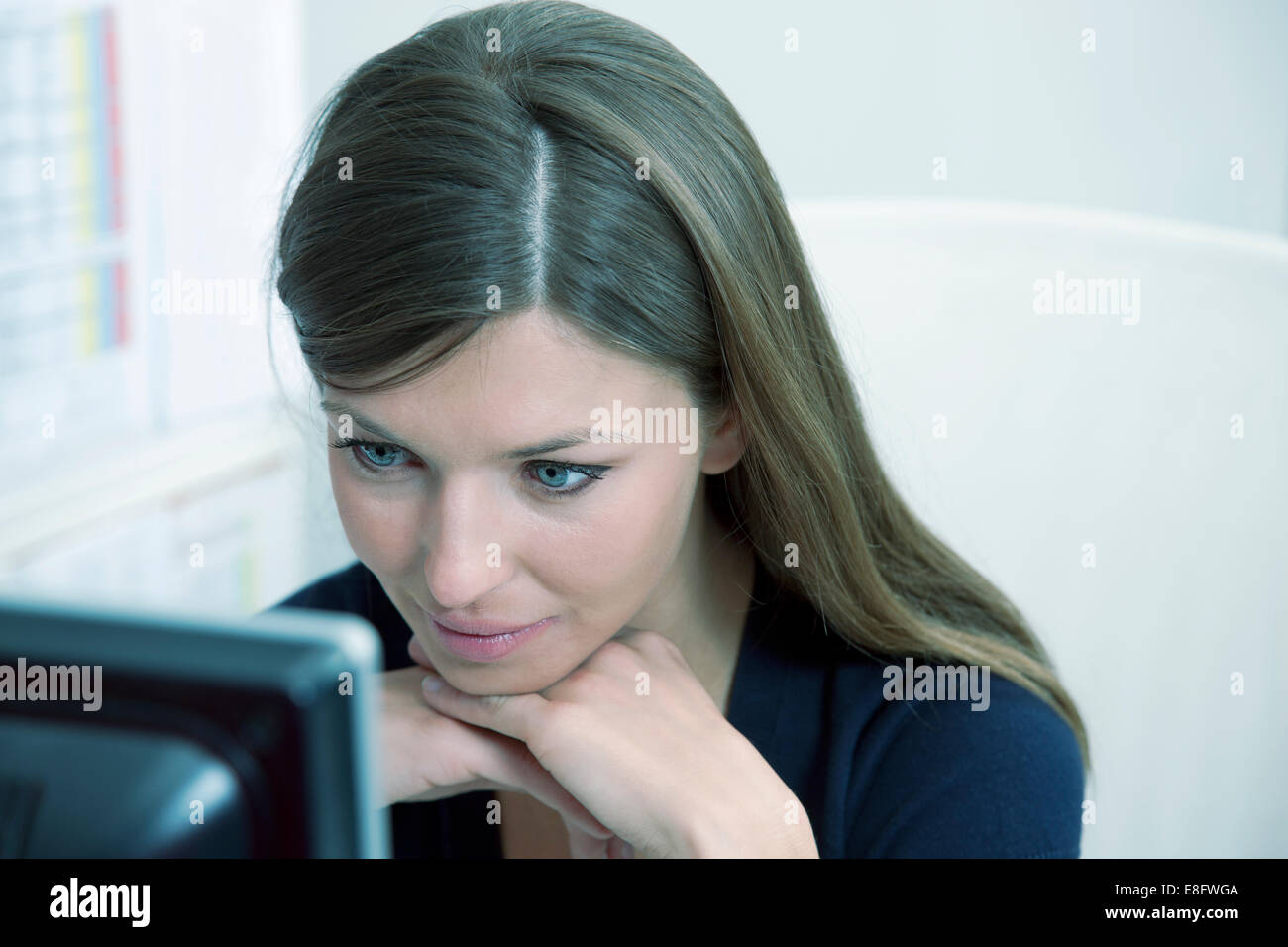 Portrait of woman working, looking at computer monitor in office Stock ...