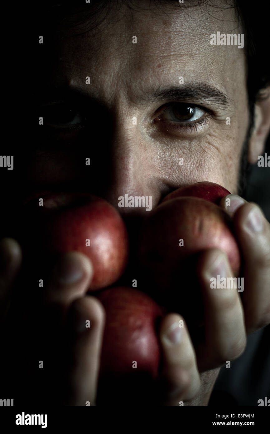 Man holding apples in front of his face Stock Photo - Alamy