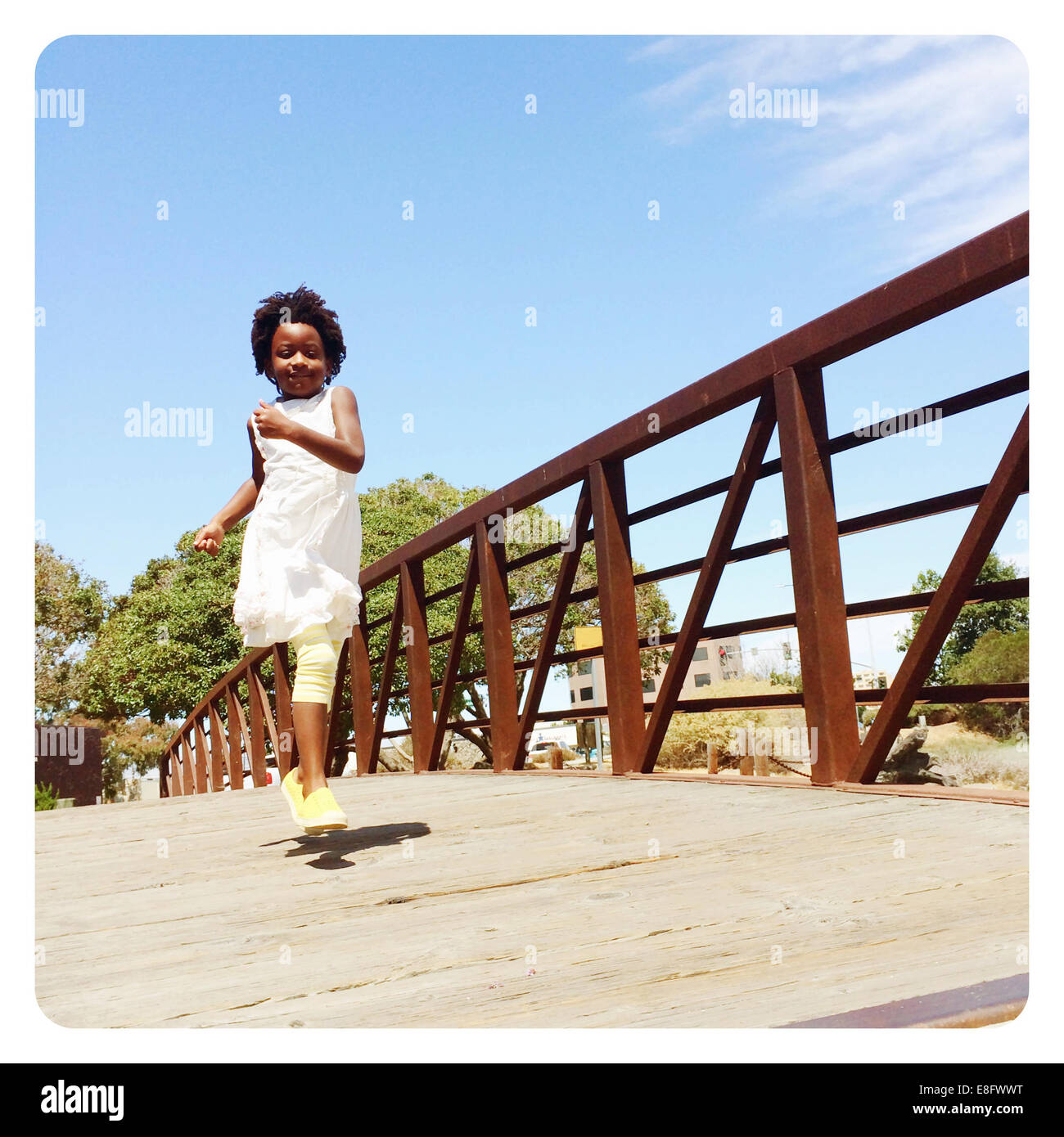 Girl running across bridge Stock Photo - Alamy