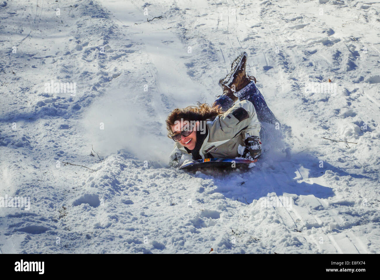 Mature woman having fun on sled, Pennsylvania, United States Stock ...