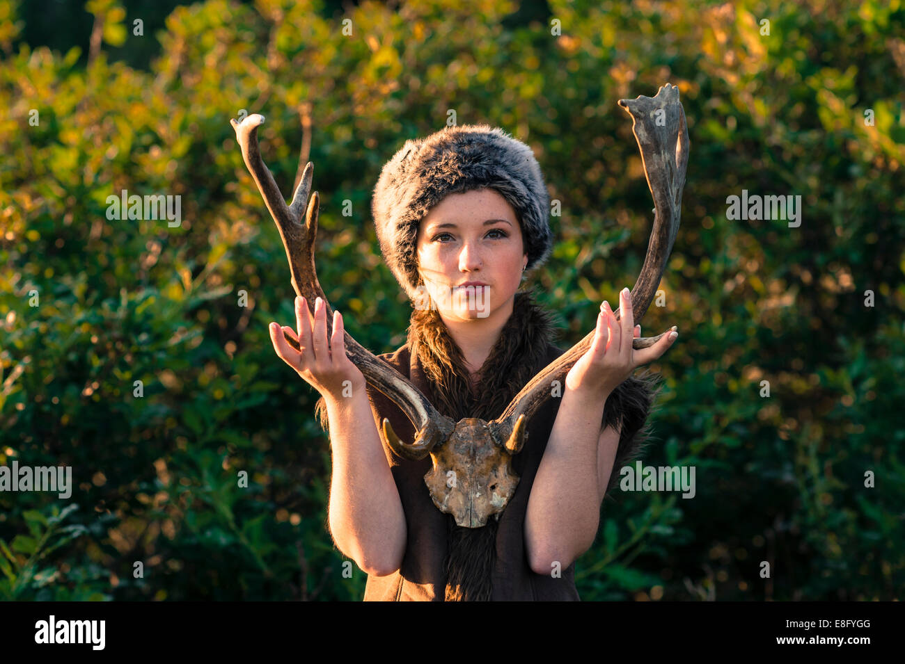 A young pagan woman girl model holding a pair of reindeer antlers ...