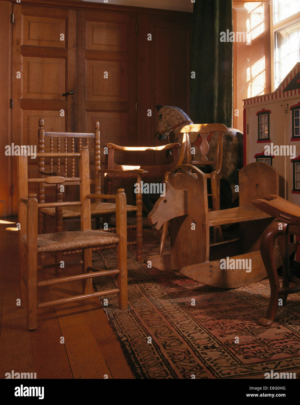 Antique rush seated chairs and old rustic rocking horse in unused ...