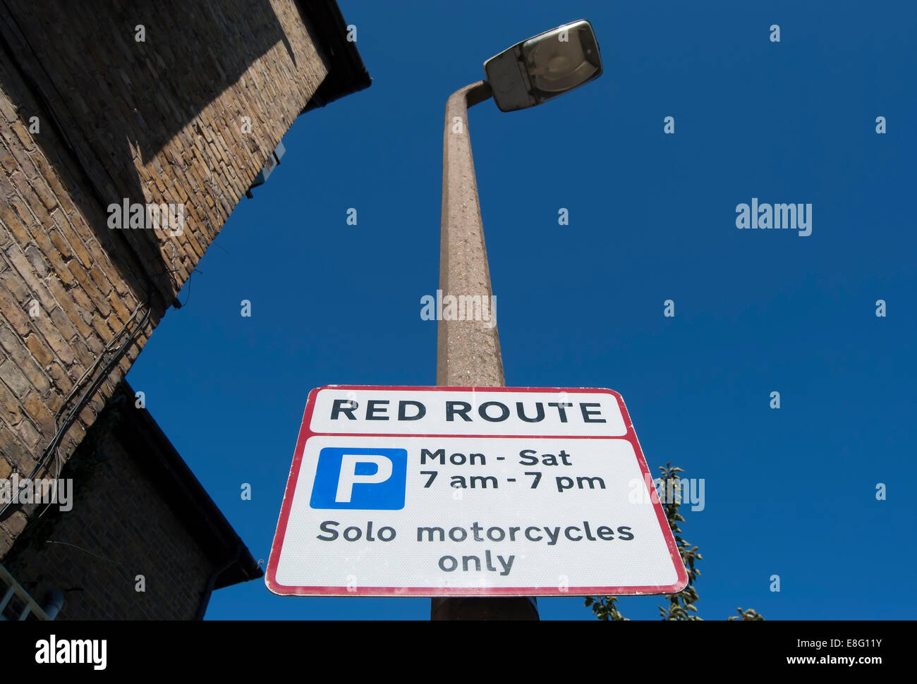 british road sign indicating a red route and a parking space for solo ...