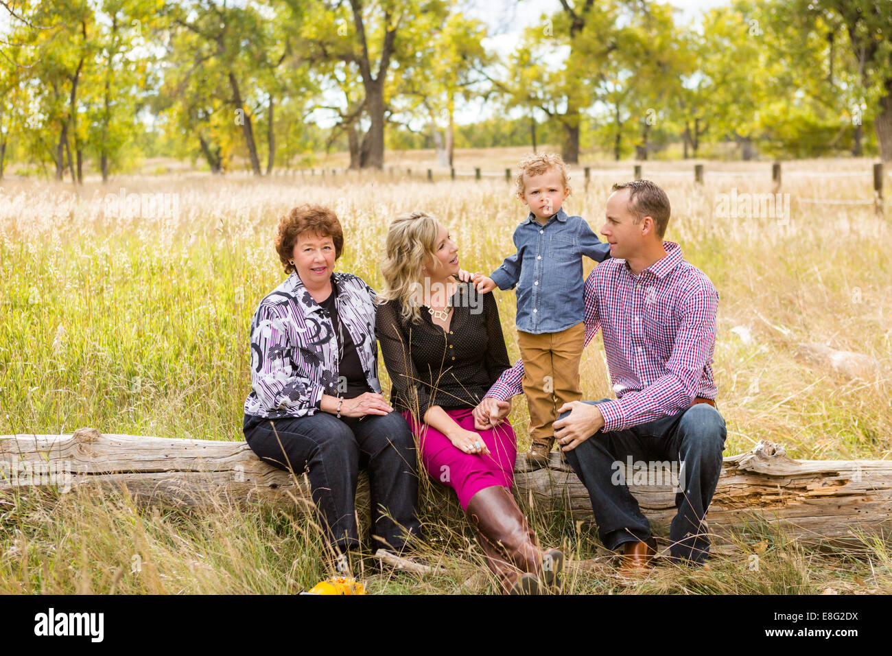 Lovely family enjoying weekend in open space park in early Autumn Stock ...