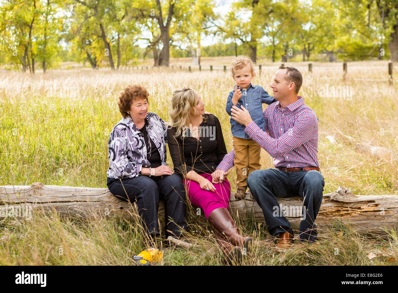 Lovely family enjoying weekend in open space park in early Autumn Stock ...
