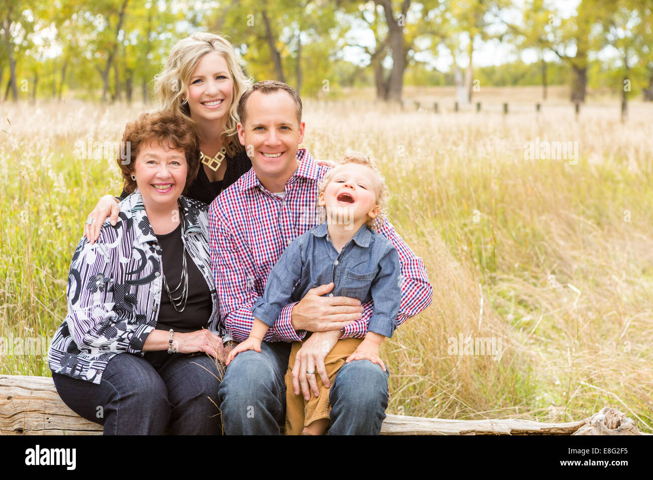 Lovely family enjoying weekend in open space park in early Autumn Stock ...