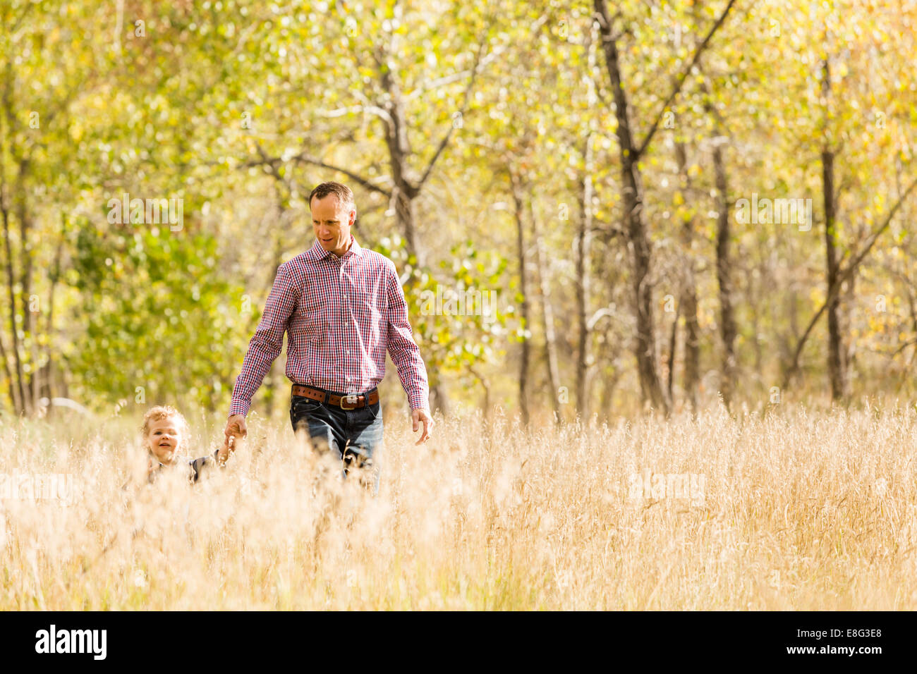 Lovely family enjoying weekend in open space park in early Autumn Stock ...