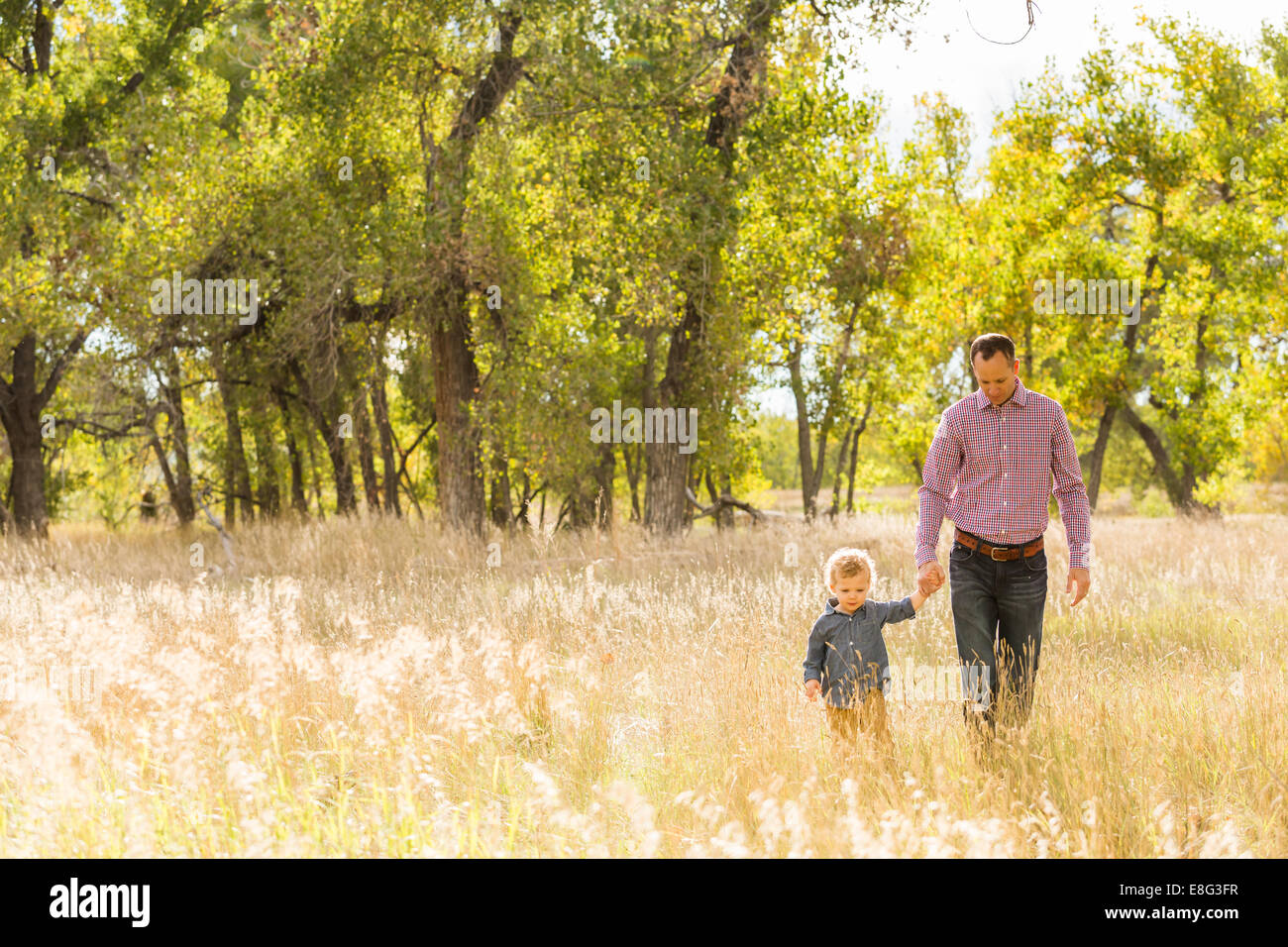 Lovely family enjoying weekend in open space park in early Autumn Stock ...