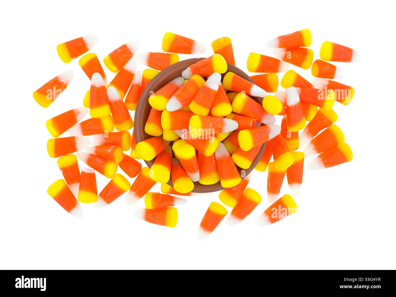 A mess of Halloween candy corn kernels on a white background with a ...