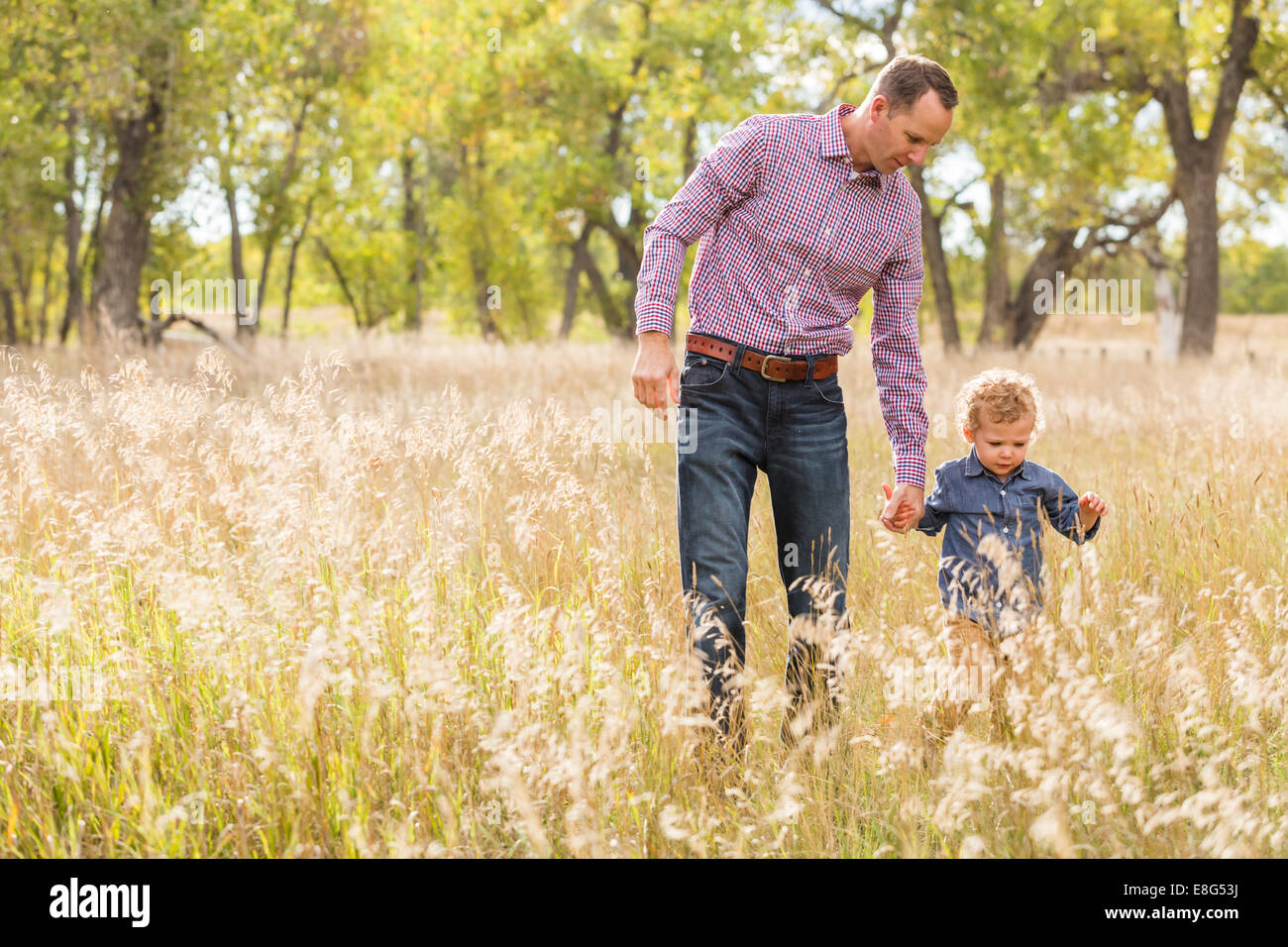 Lovely family enjoying weekend in open space park in early Autumn Stock ...