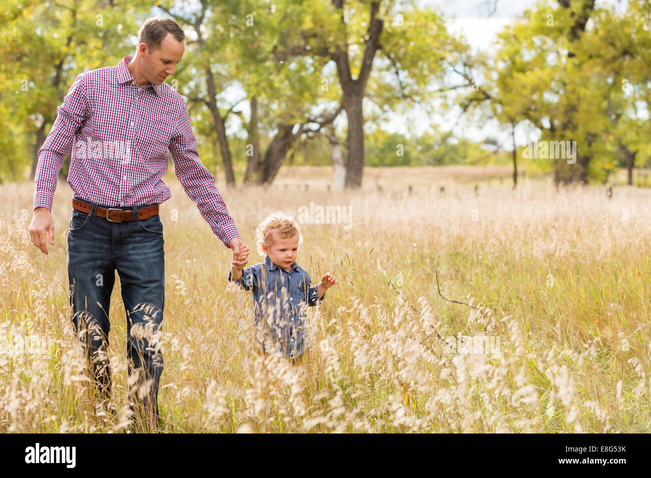 Lovely family enjoying weekend in open space park in early Autumn Stock ...