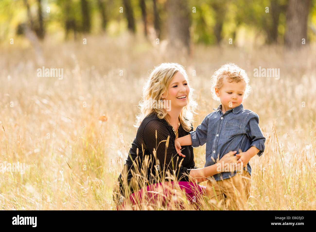 Lovely family enjoying weekend in open space park in early Autumn Stock ...