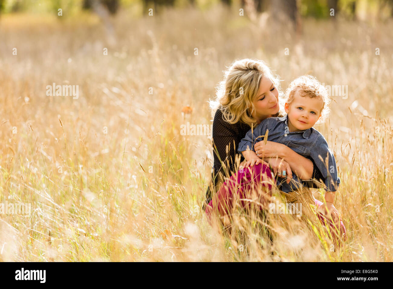 Lovely family enjoying weekend in open space park in early Autumn Stock ...