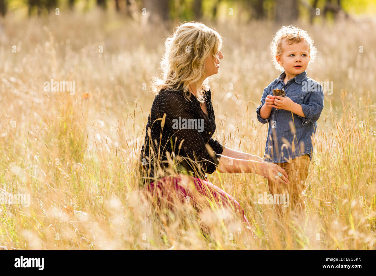 Lovely family enjoying weekend in open space park in early Autumn Stock ...