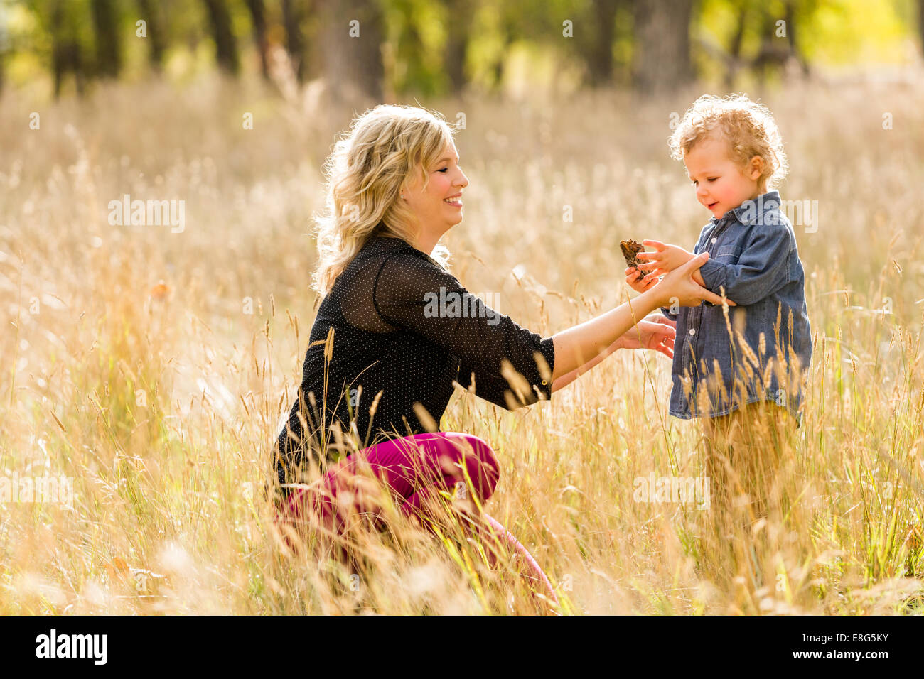 Lovely family enjoying weekend in open space park in early Autumn Stock ...