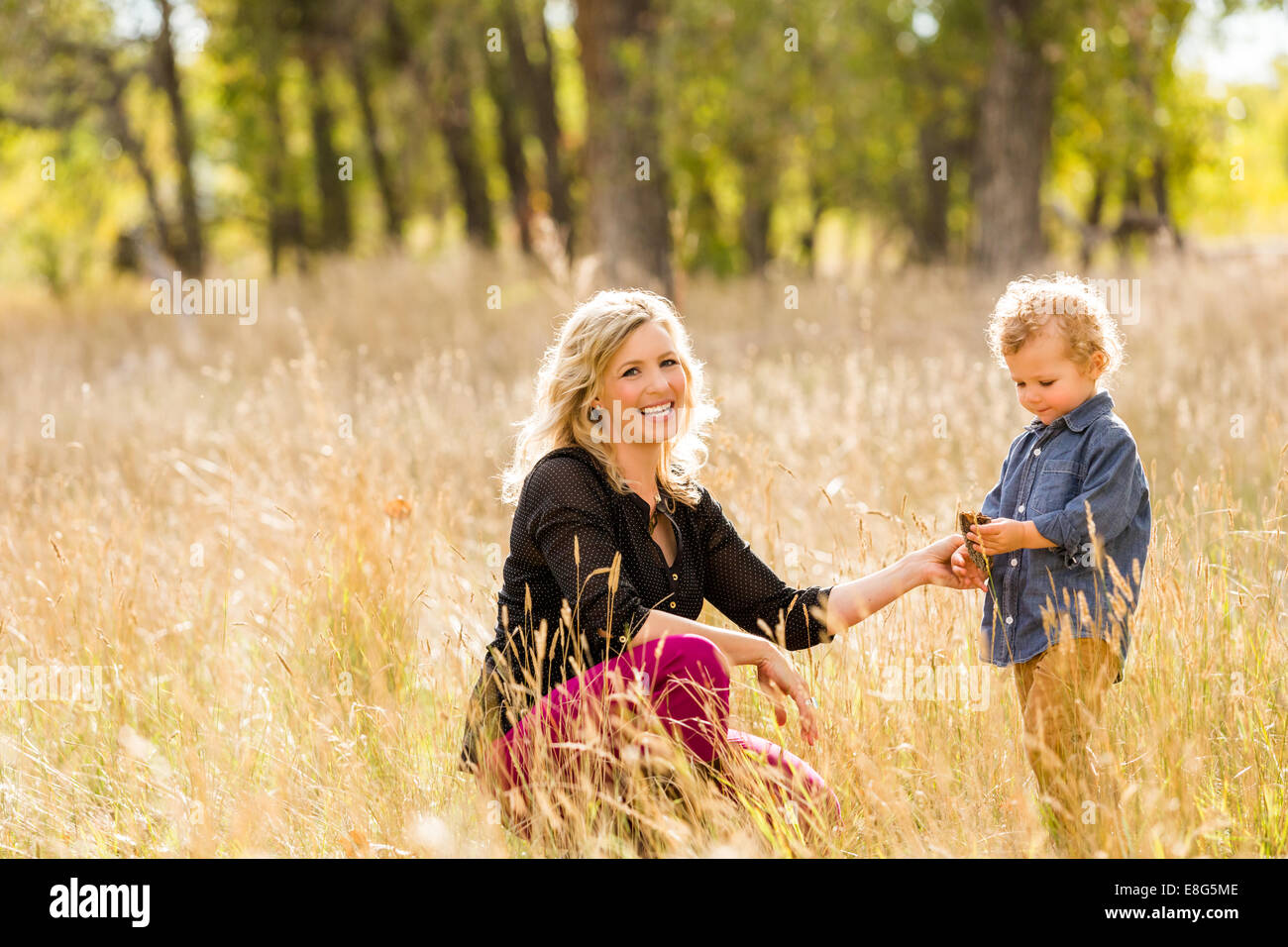 Lovely family enjoying weekend in open space park in early Autumn Stock ...